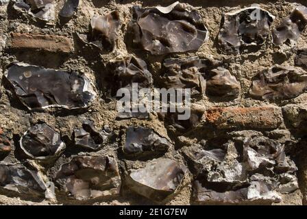 Rough and unfinished flint facade of an ancient wall near the Cathedral ...