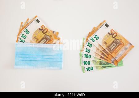 Euro banknotes with face mask lying on the table. . bank spread ...