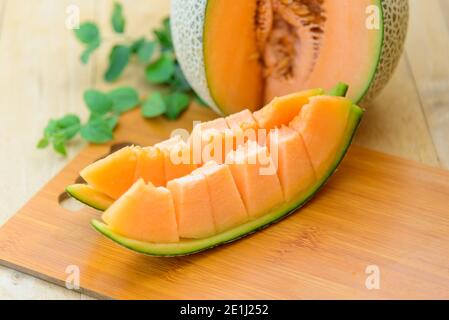 split the orange melon on wood plate Stock Photo - Alamy