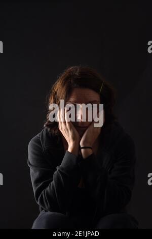 pensive woman with downcast eyes on black background Stock Photo - Alamy