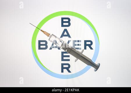 Medical syringe is seen with Bayer logo displayed in the background in ...