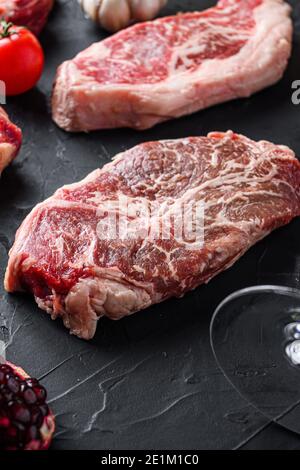 Flat Iron beef steak cuts, with herbs, seasoning on black table, side ...