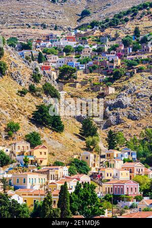 Greece, Island of Symi: classical houses crowding the hillside across ...