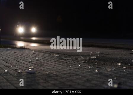 Ice smashed on a lantern lit sidewalk at night, blurred background with ...