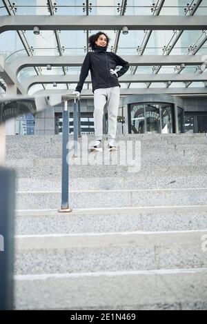 Confident athlete leaning on railing Stock Photo - Alamy