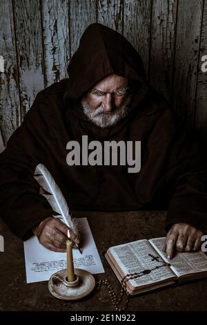 Franciscan monk writing in his cell, with his bible to hand Stock Photo ...