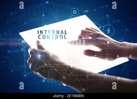 Holding futuristic tablet with INTERNAL CONTROL inscription, cyber ...