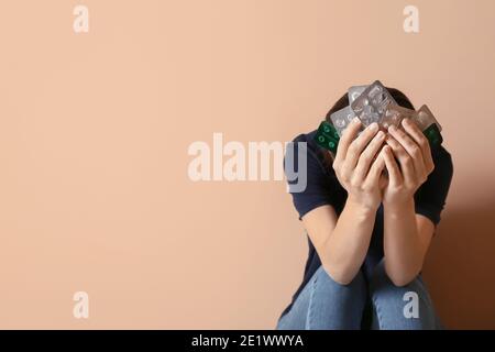 Female junkie sitting near color wall Stock Photo - Alamy