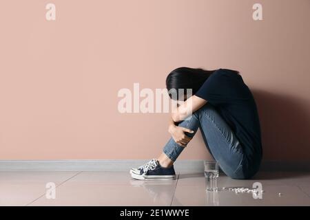 Female junkie sitting near color wall Stock Photo - Alamy
