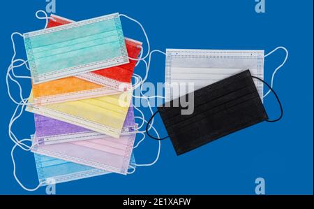 Different colored medical masks on blue background Stock Photo - Alamy