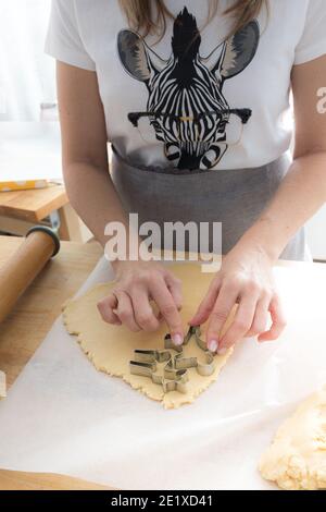 Woman cutting baking paper on white wooden background, closeup Stock ...