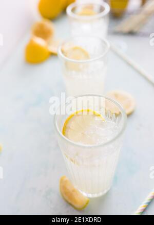 Two glasses of lemonade and pieces of lemon, green leaves on a yellow ...
