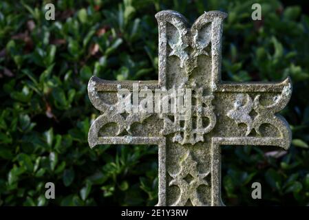 Old stone cross against green foliage in St Margaret's churchyard ...