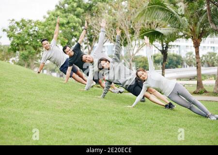 Group Of Fit People Doing Stretching Exercise On White Background Stock ...