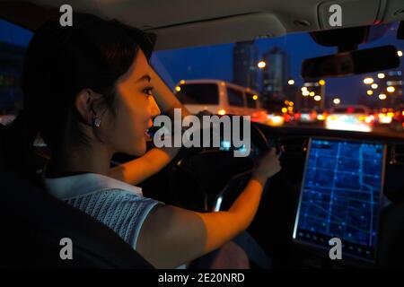 Night driving young woman look at the screen navigation Stock Photo - Alamy