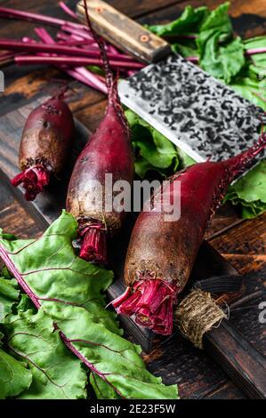 Purple beetroot on a cutting board. Dark wooden background. Top view ...