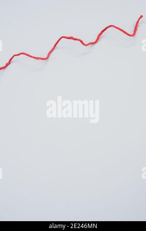 Vertical shot of a bright red thread on a peach background Stock Photo ...