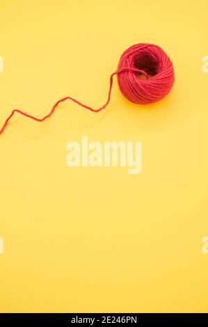 Vertical shot of bright red woolen yarn on a yellow background Stock ...