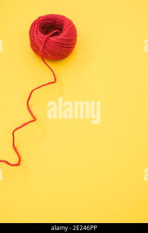 Vertical shot of bright red woolen yarn on a yellow background Stock ...