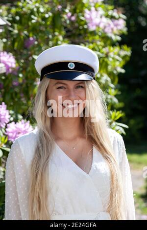 Blonde caucasian woman wearing graduation cap smiling with happy face ...