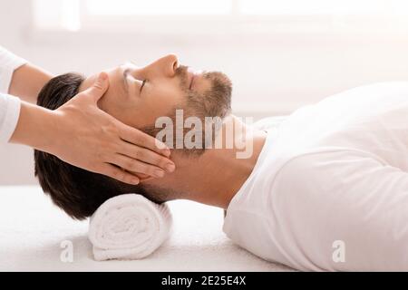 Female therapist making relaxing head massage for handsome man Stock ...