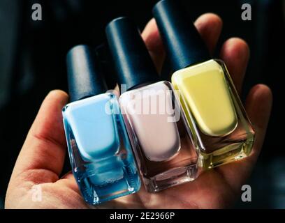 Woman hand with pastel manicure polish holding small glass bottle ...