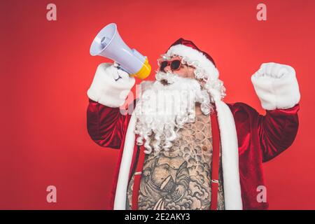 Funny crazy santa claus with tattoo having fun on a red colored ...