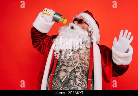 Funny crazy santa claus with tattoo having fun on a red colored ...