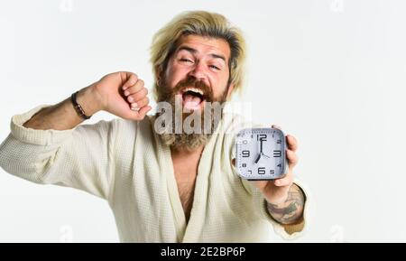 happy handsome angry man lies in bed indoors wake up turn off the alarm ...