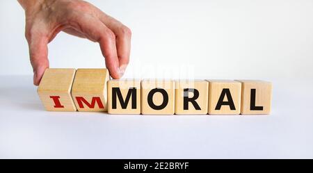 Moral or immoral symbol. Hand turns cubes and changes the word 'immoral ...