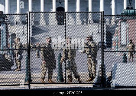 National Guard troops standing guard by non-scalable fencing that was ...