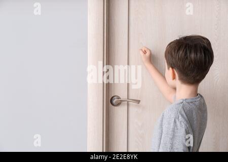 Cute little boy knocking at the door Stock Photo - Alamy