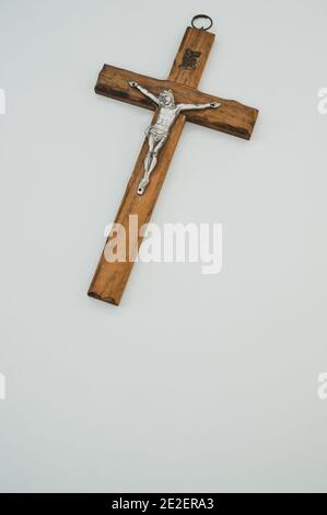 Vertical shot of a wooden crucifixion of Christ cross on a pastel peach ...
