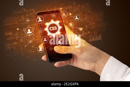 Female hand holding smartphone with CSS abbreviation, modern technology ...