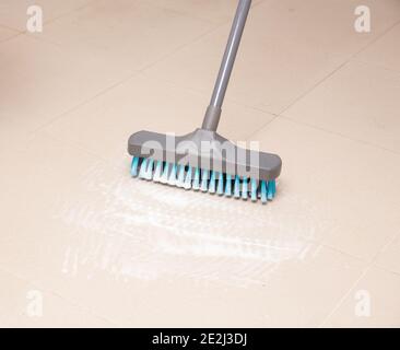 Cleaning ceramic tile floor with scrub brush and sponge. Housekeeping ...