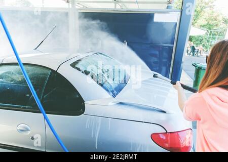 Pretty Woman Washing Her Car With High Pressure Washer At Self-Serve ...