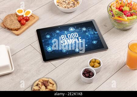 BLOOD SAMPLE concept in tablet pc with healthy food around, top view ...