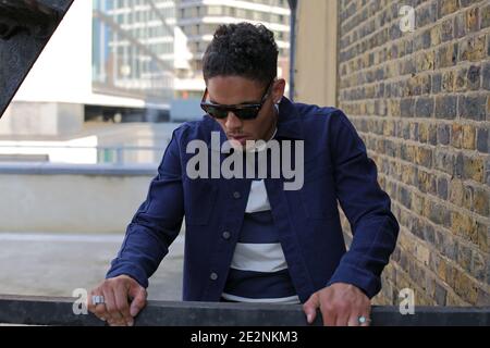 Young emotional man, looking down at pda on beige background Stock ...