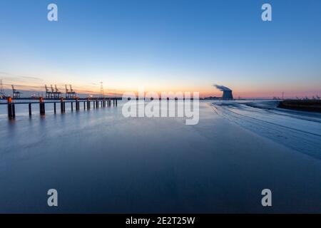 Jetty at the river Scheldt, with in the distance a view of the cooling ...