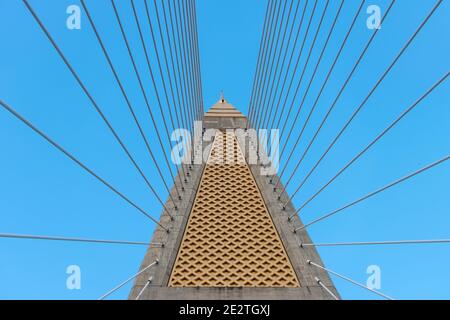 Concrete bridge pylon with parallel lines of steel cable. Passage under ...