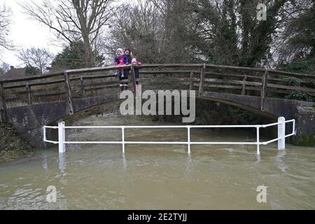 People cross a bridge over a swollen River Chelmer in the village of ...