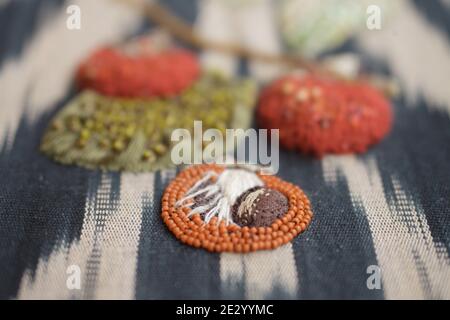 Couture embroidery of persimmon on ikat fabric. Still life with fruits ...