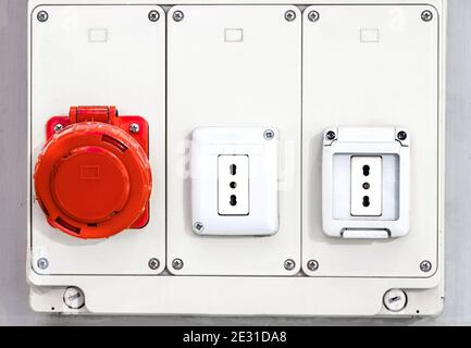 Plastic panel with white electrical sockets and cable connectors on the ...