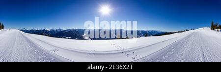 A beautiful winter scene of the snowy Alpen and a skier holding a ...