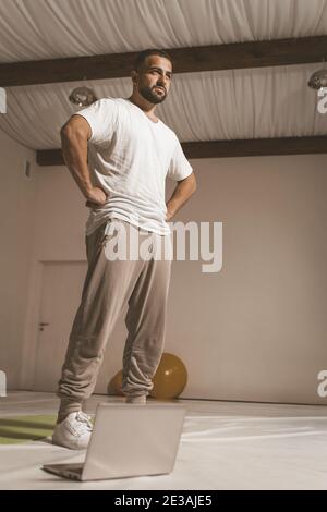 Sporty young man with laptop training in gym Stock Photo - Alamy