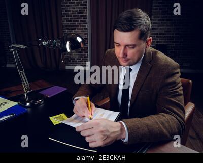 businessman sitting at table at night office Stock Photo - Alamy