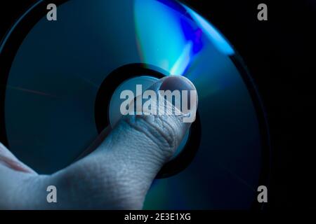 compact-disc in hand on a black background Stock Photo - Alamy