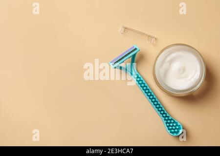 Razor and cosmetic cream on beige background Stock Photo - Alamy