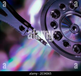Computer hard drive, opened, writing/reading head and hard disk. Binary code numbers are ...