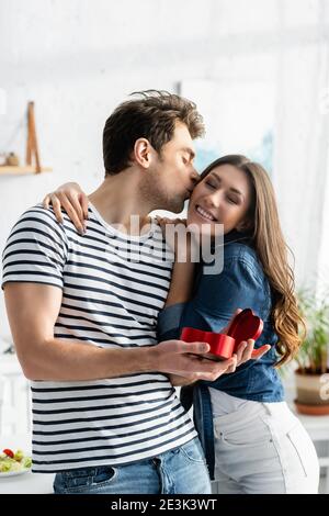 smiling woman hold heart present box on blue background Stock Photo - Alamy